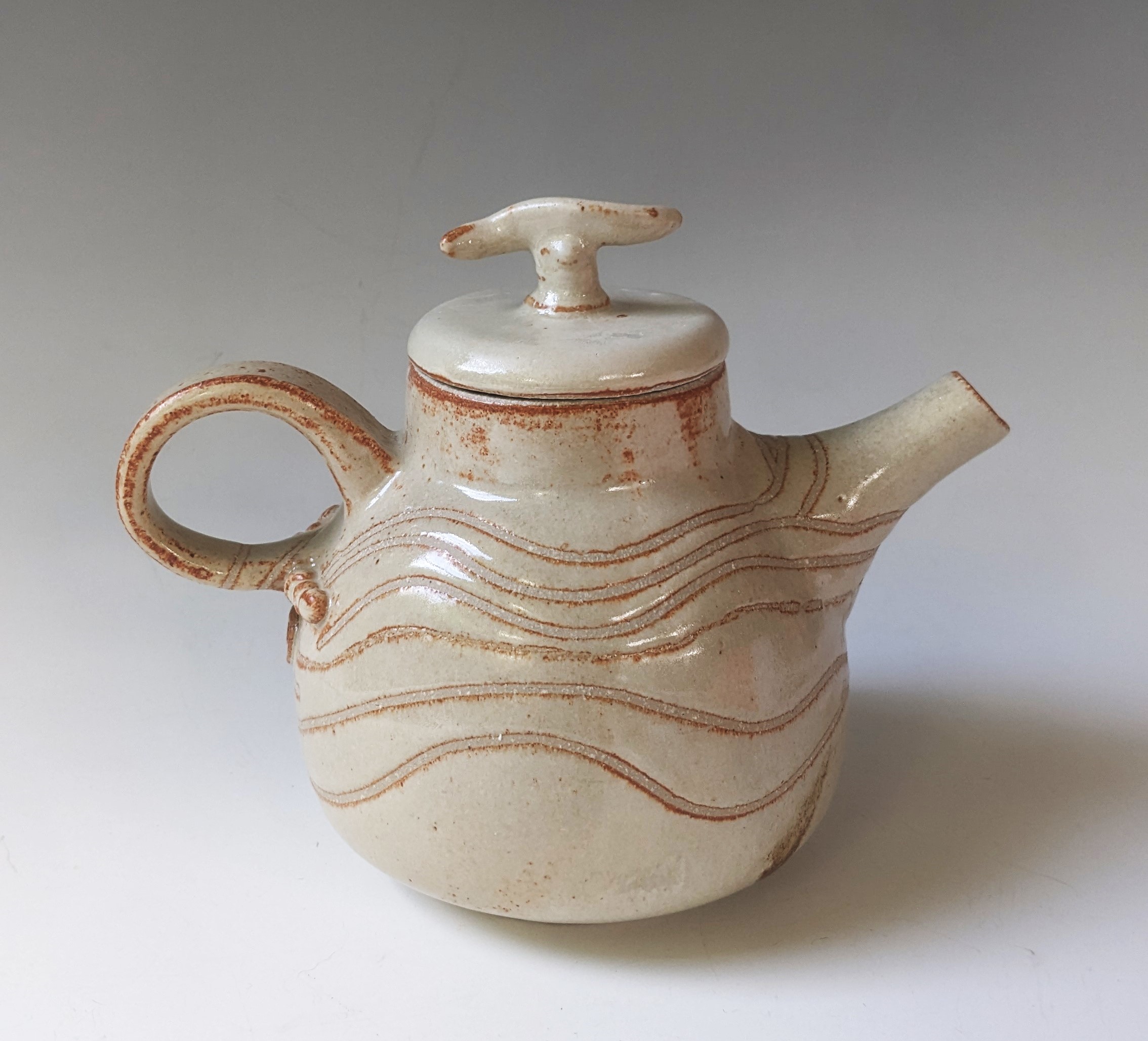 Creamy teapot with wavy lines